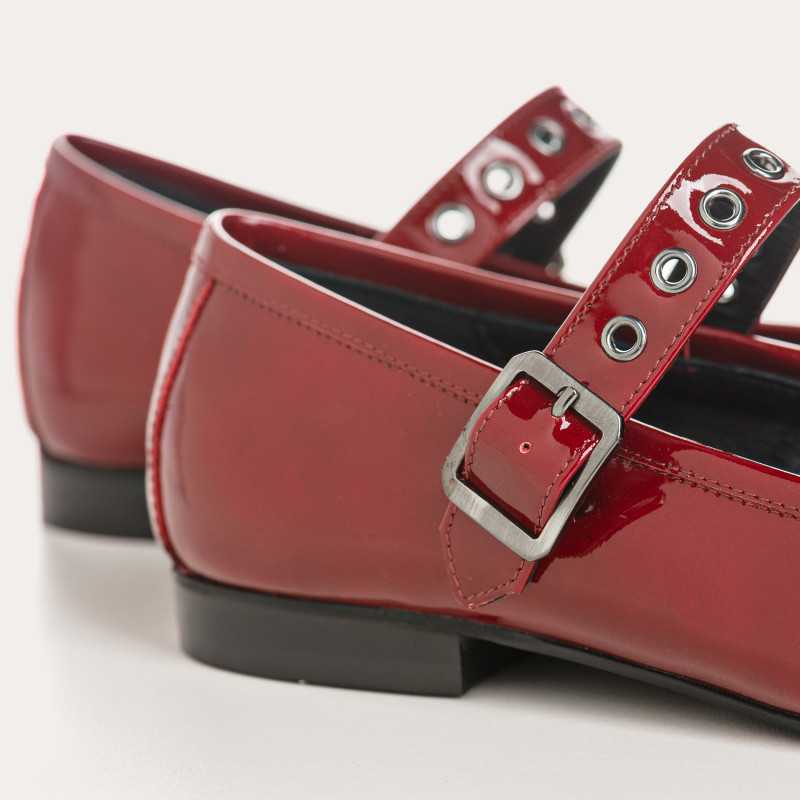 Babies rouges en cuir vernis avec œillets et boucles argentées